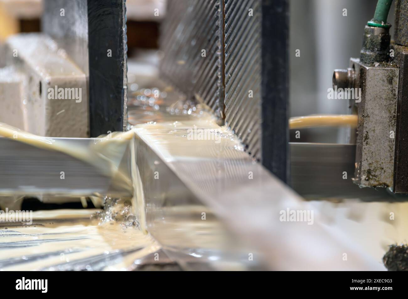 Automatic band saw machine cutting the metal rod with water base ...