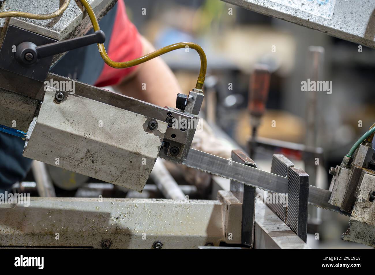 Automatic band saw machine cutting the metal rod with water base ...