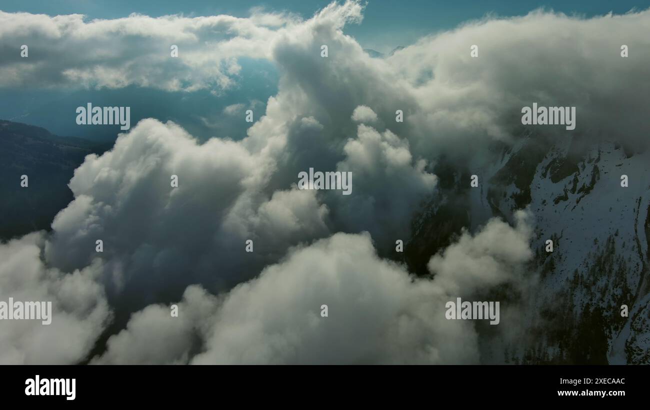Flying through clouds between mountains Stock Photo - Alamy