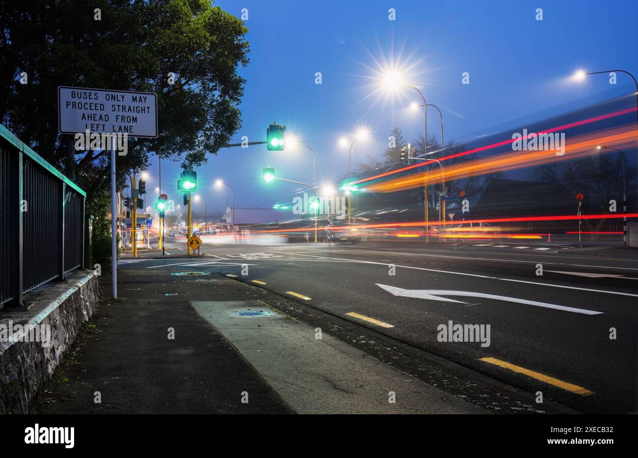 Long exposure image of bus light trails driving through green traffic ...