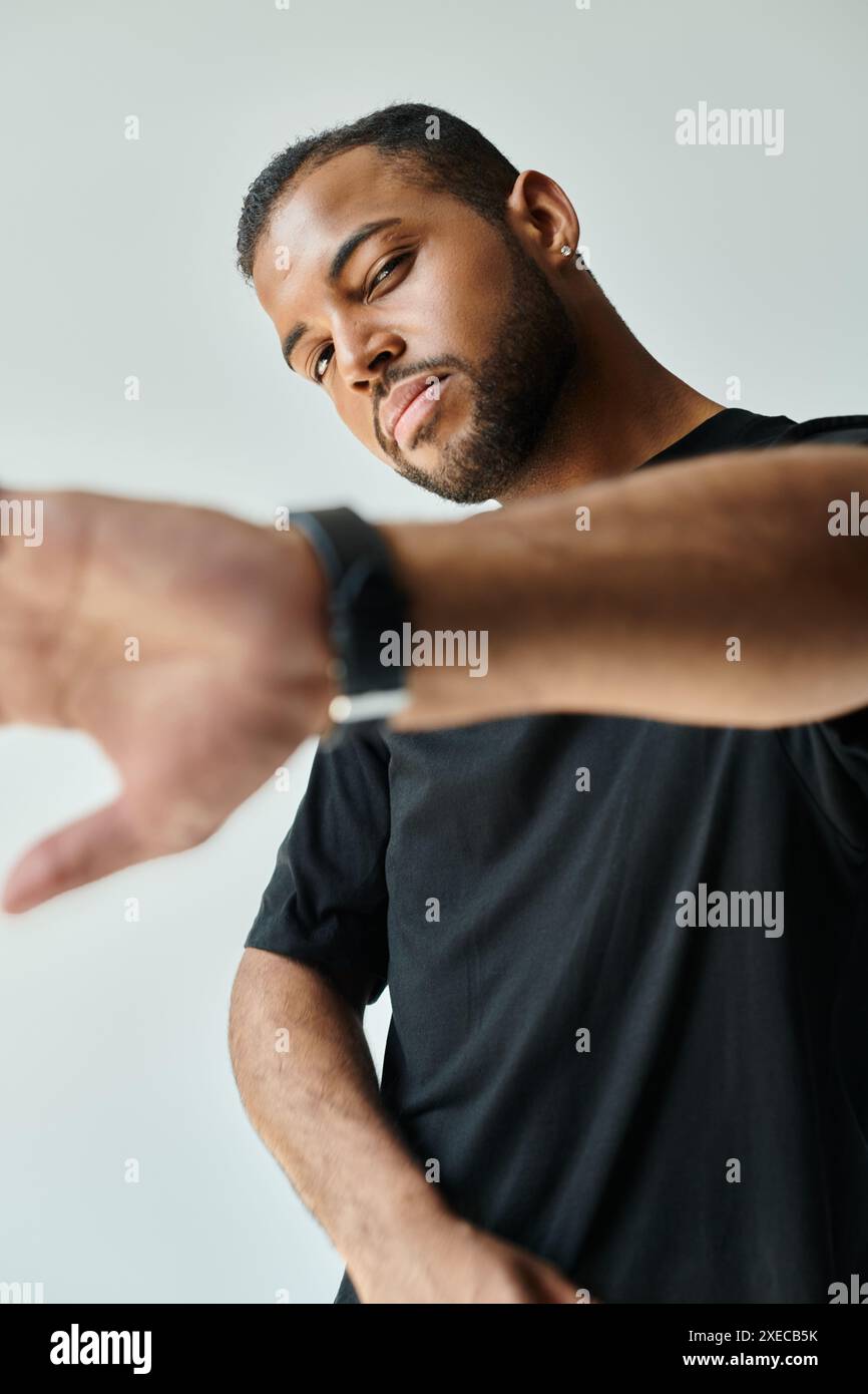 A stylish African American man pointing towards something with his hand ...