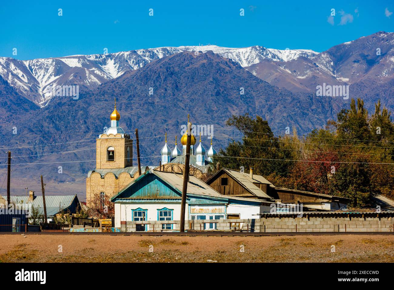 Small Kyrgyz town Balykchy cityscape in front of massive mountain ridge ...