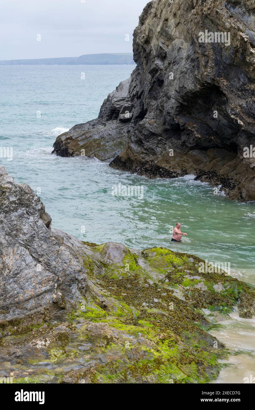 A mature man bathing waist deep in the sea at Towan Beach in Newquay in ...