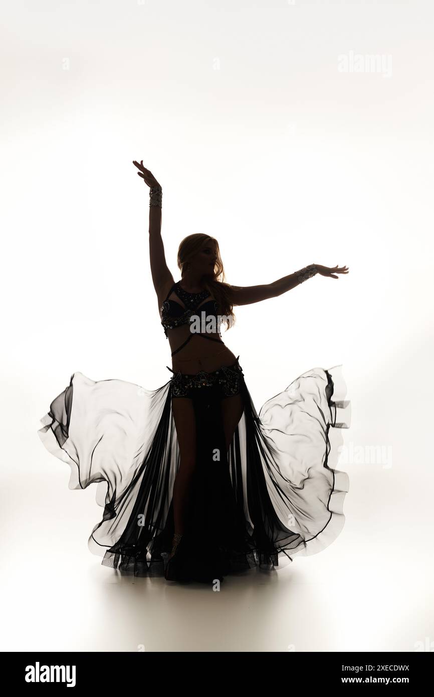 Graceful woman in black and white dress dancing with fluid movements ...