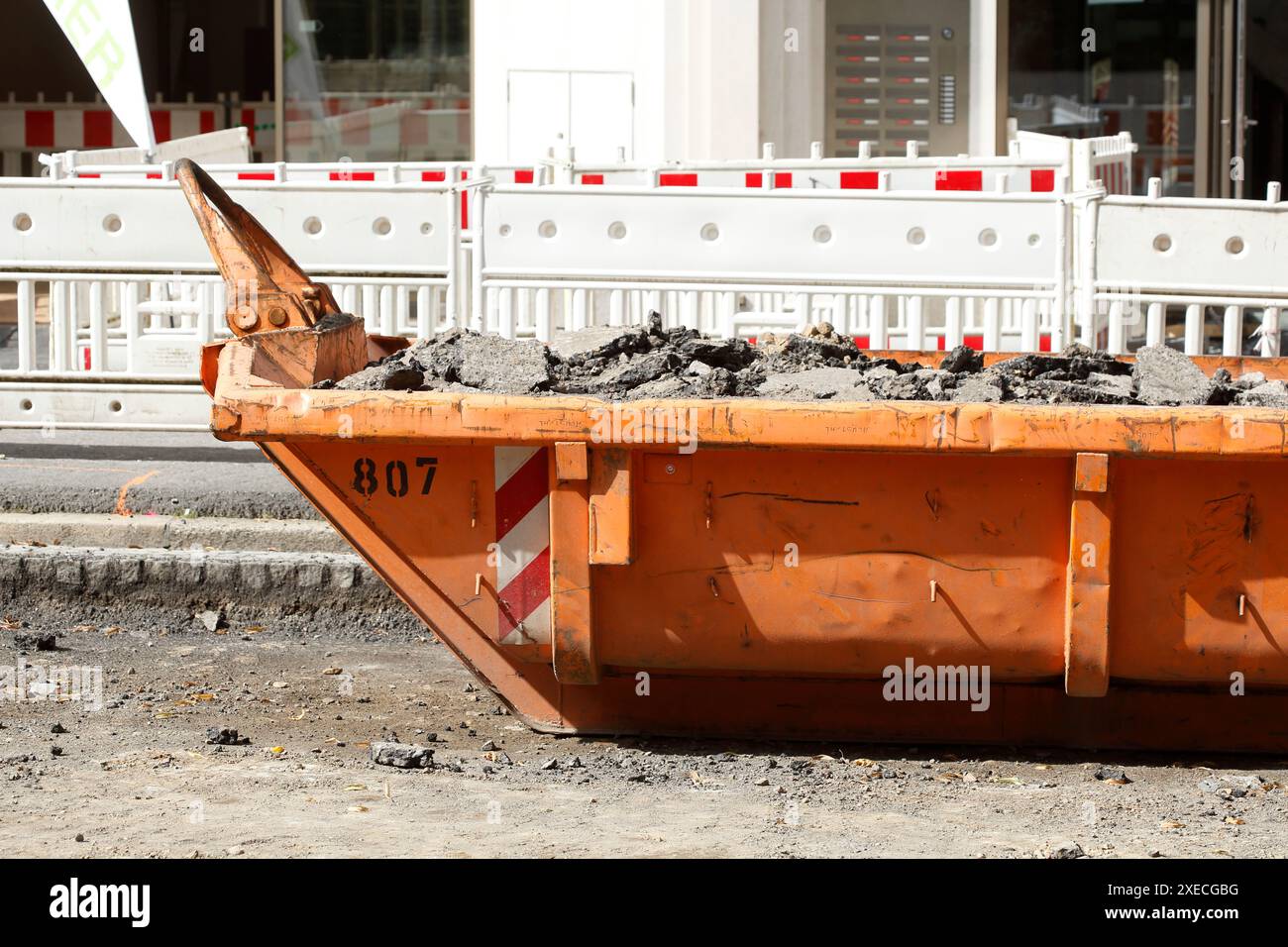 Container, orange skip for construction waste standing on the road ...