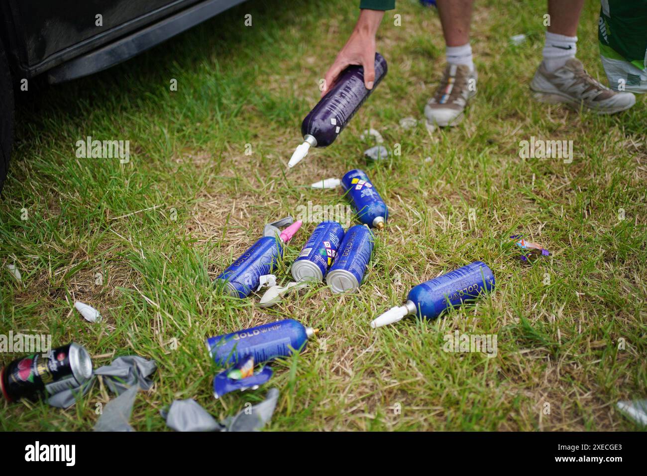 A member of the Glastonbury cleaning team clearing up discarded nitrous ...