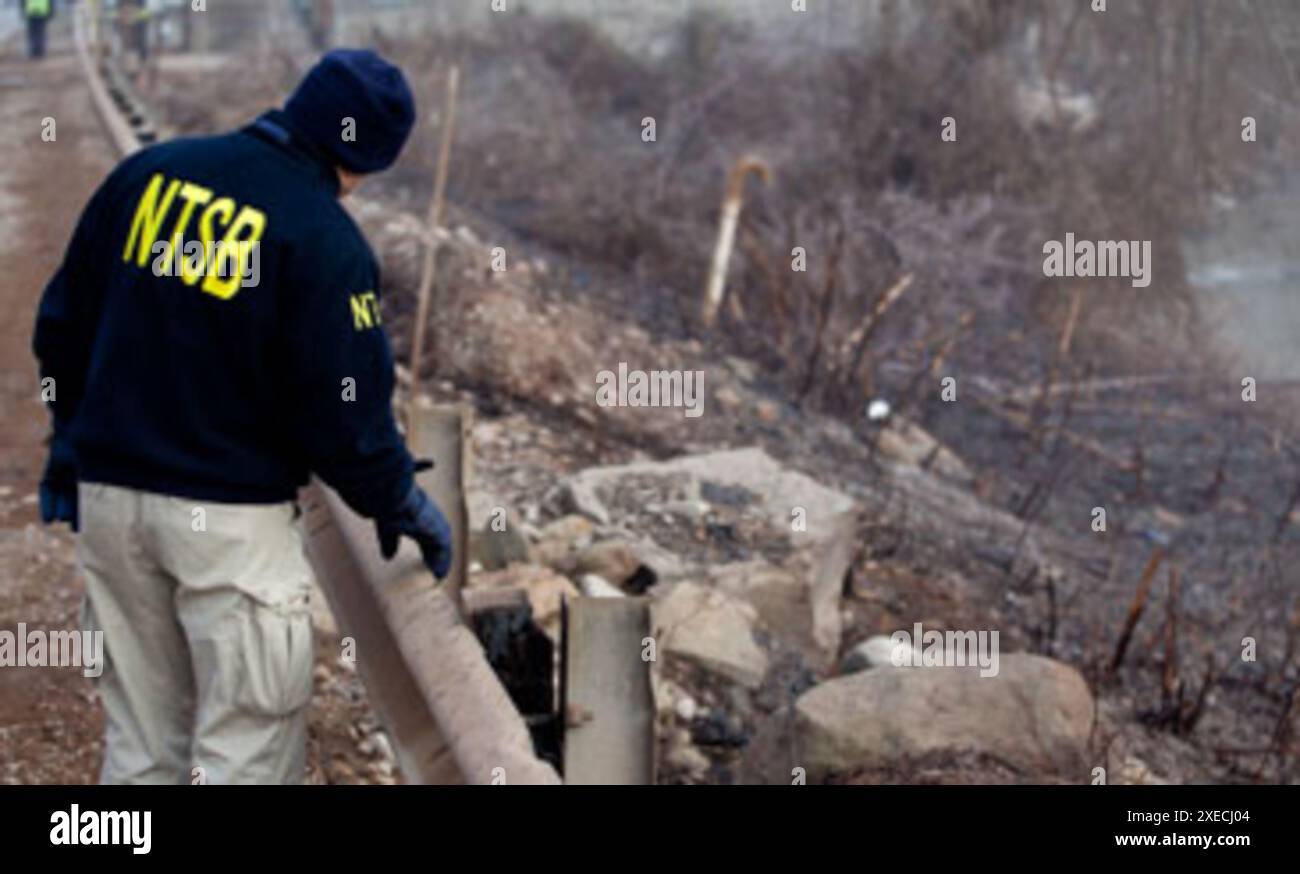 NTSB Public Affairs Specialist Eric Weiss looks at the damaged wood ...