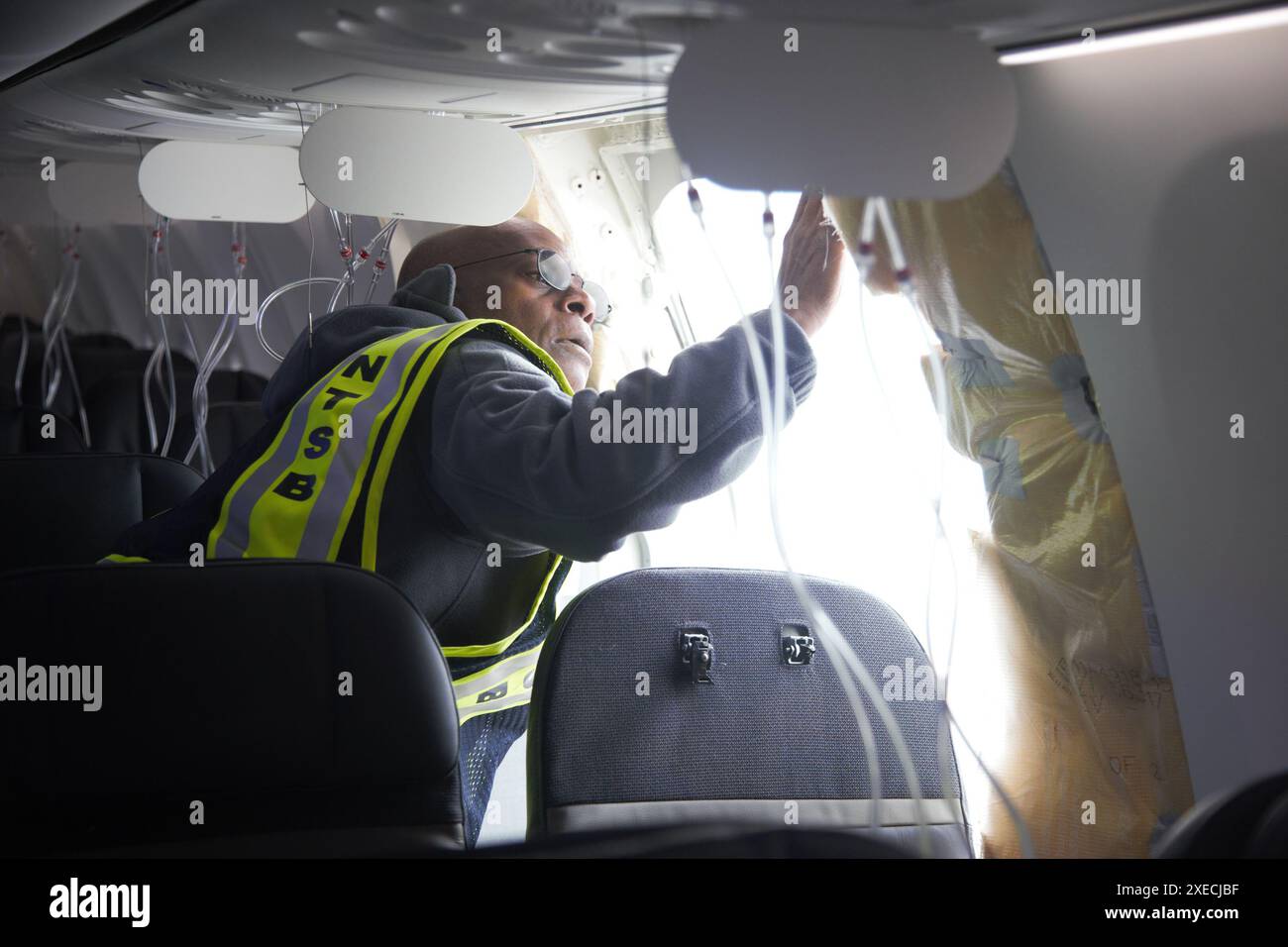 Investigator-in-Charge John Lovell examines the fuselage plug area of ...