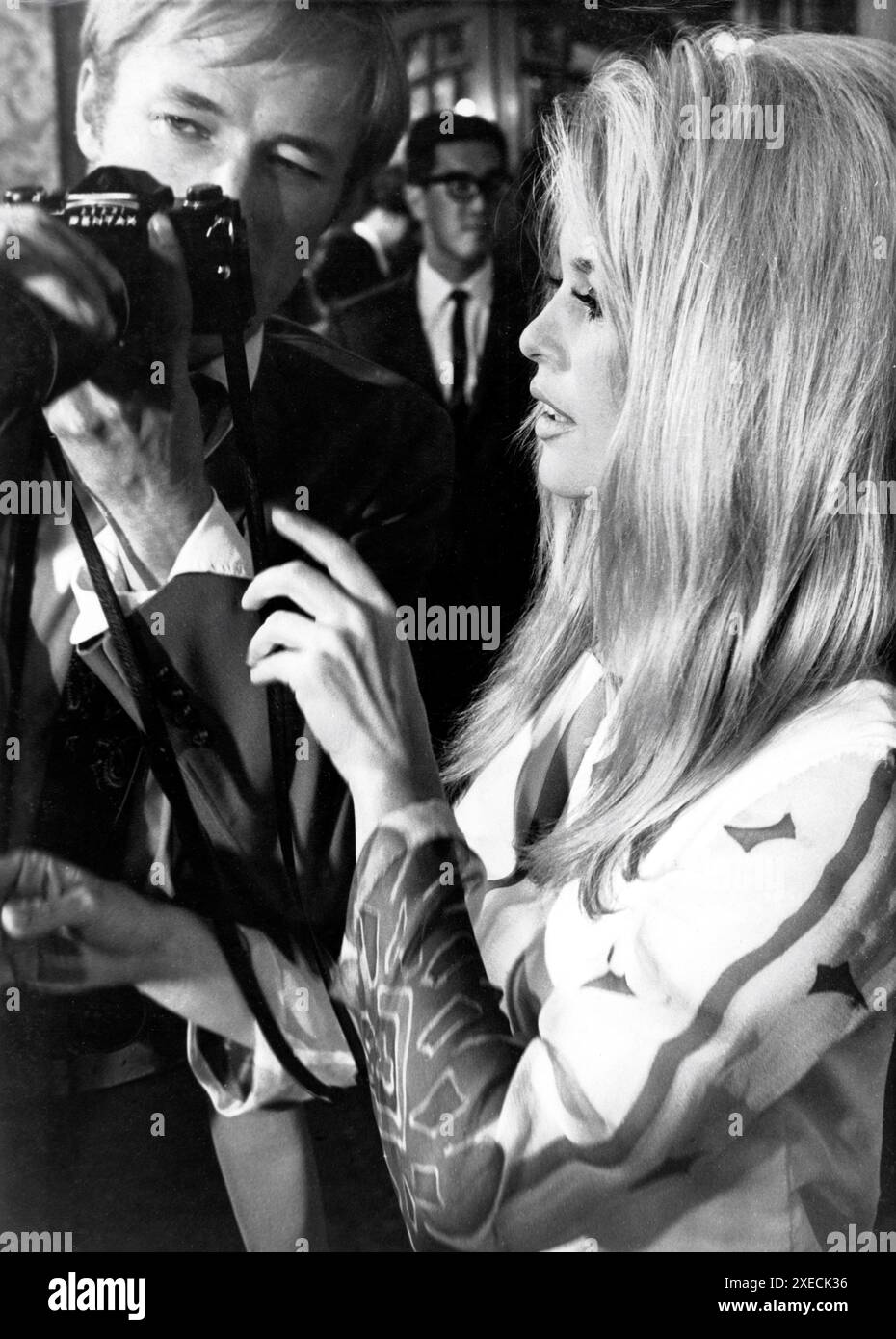 Co-Star MIKE SARNE shows his Pentax Still Camera to BRIGITTE BARDOT on ...