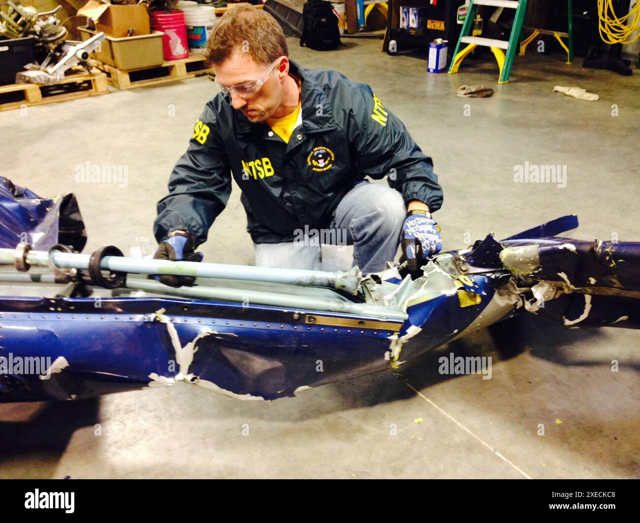 Aviation Safety Investigator Josh Cawthra examines the tail rotor drive ...