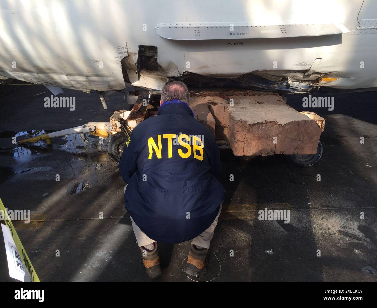 NTSB Investigator-in-Charge Dan Bower documenting damaged section of ...