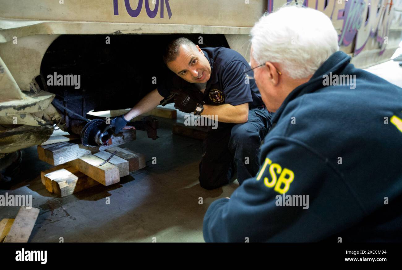 NTSB highway investigator Dave Pereira examines wheel of the DUKW ...