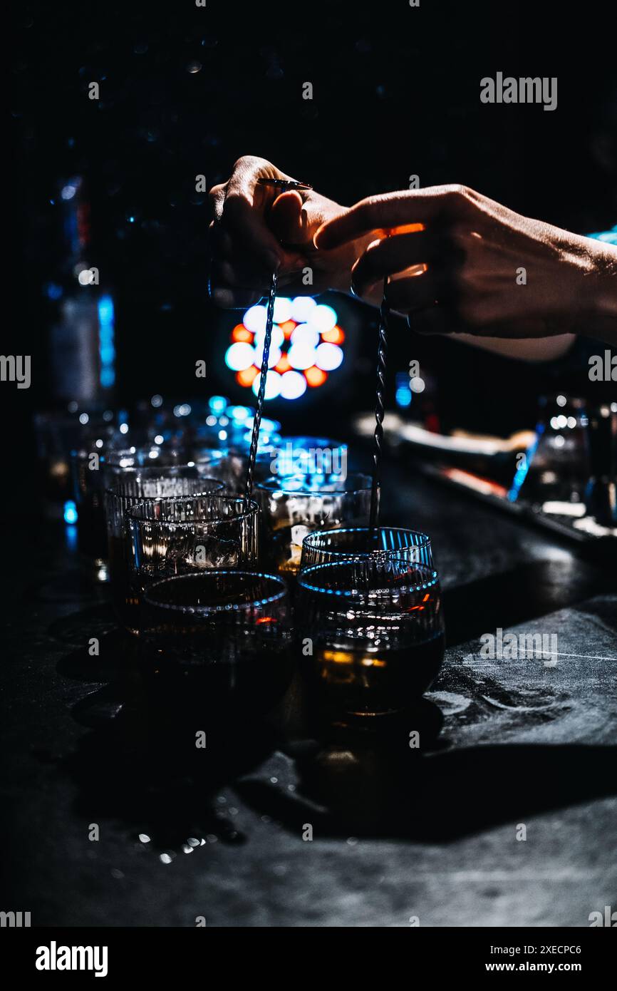Bartender Preparing Multiple coffee Whiskey Cocktails at a Busy Bar ...