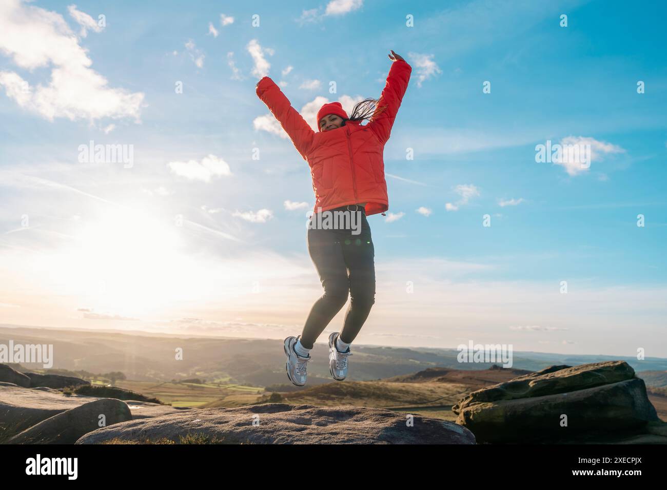happy woman reaching destination, jumping, rising hands on top of ...