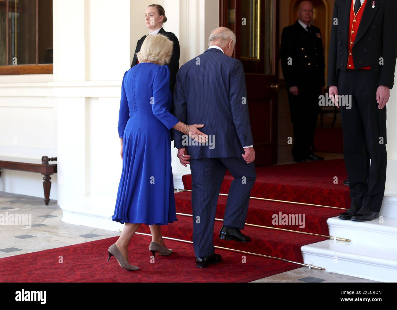 King Charles III and Queen Camilla walk back in to Buckingham Palace, London, after they ...