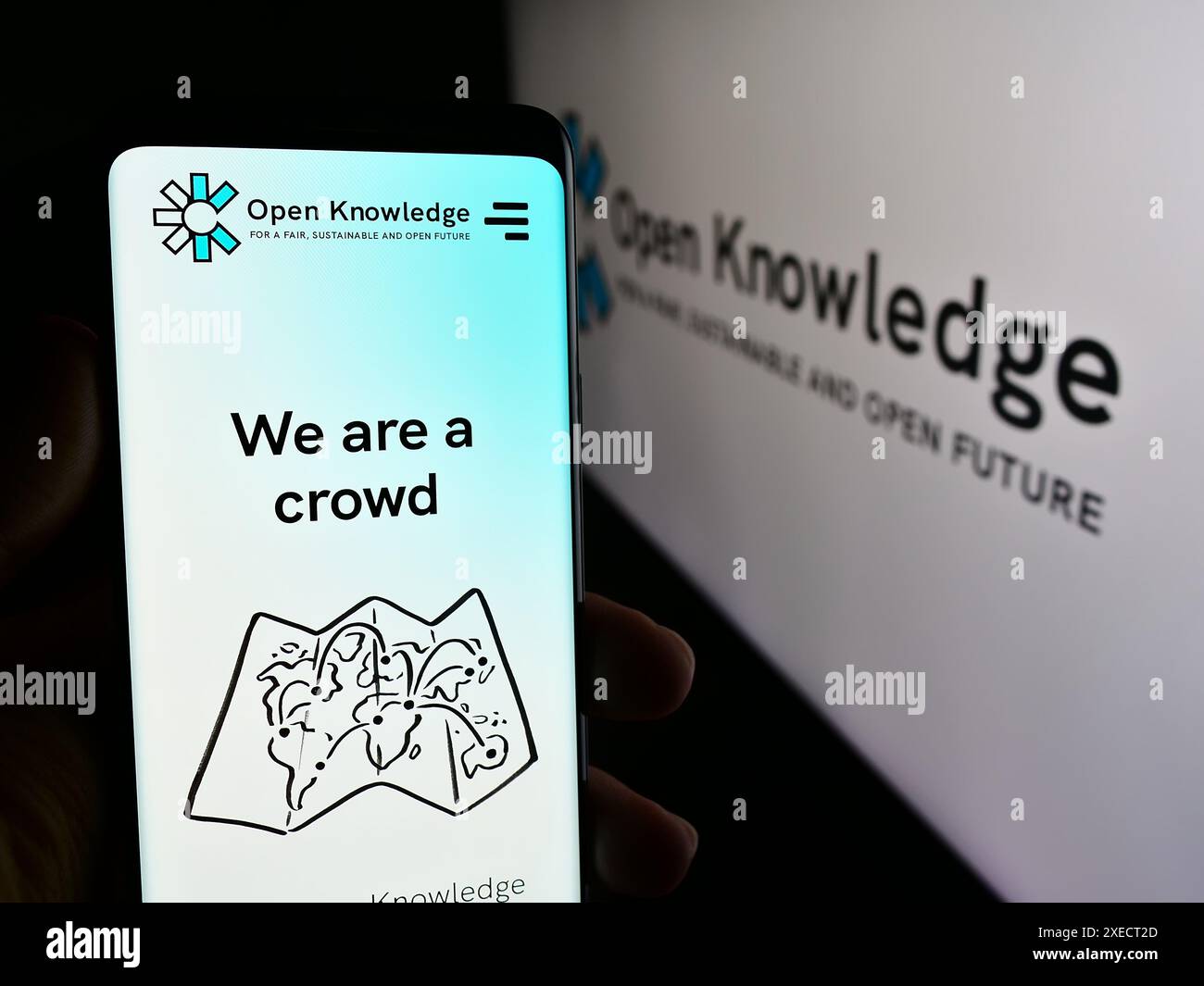 Person holding mobile phone with webpage of global organisation Open ...