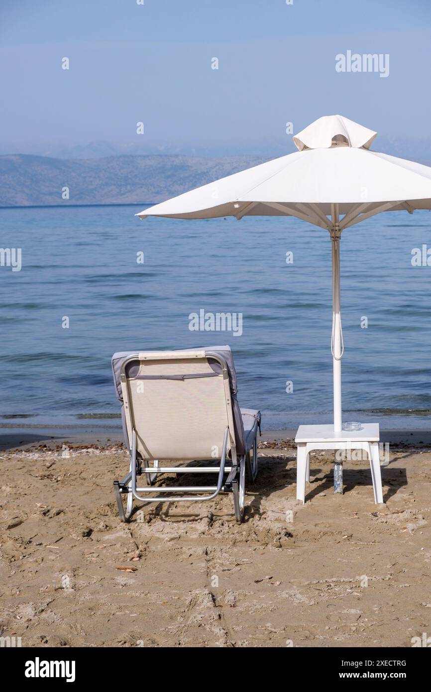 Large white parasol on a beach on Corfu in Greece, with calm deep blue ...