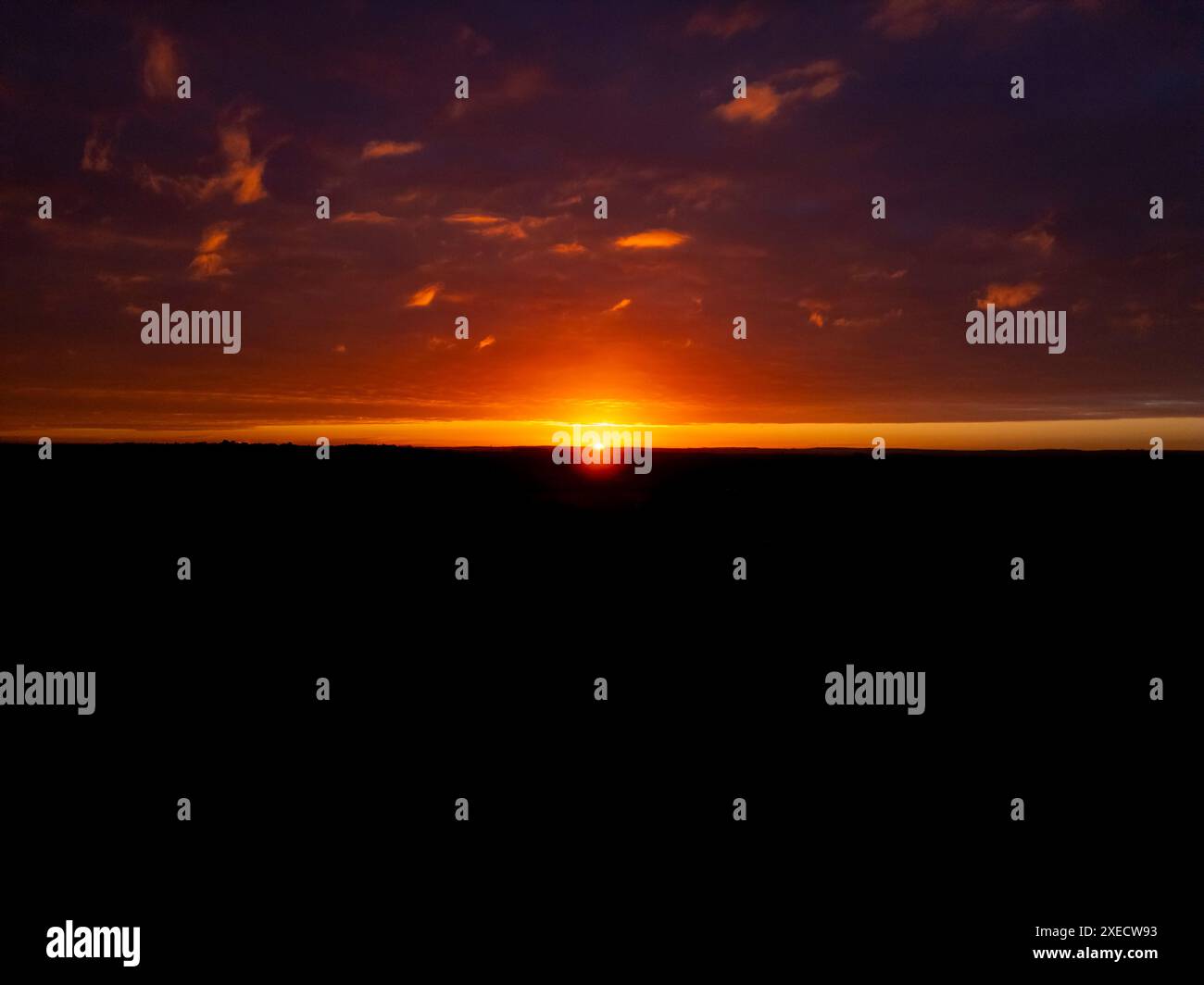 The sun rising over the horizon on a dark winter morning Stock Photo ...