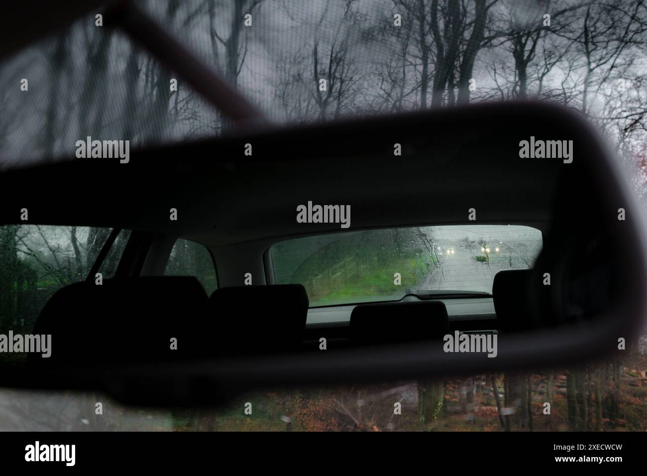 Looking through the rain covered rear window of a car as viewed in the ...