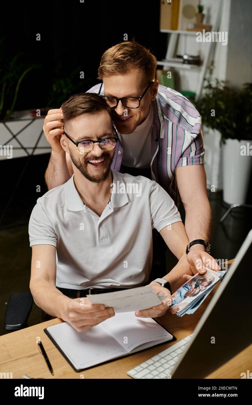 Two men in casual outfits collaborate at a desk in an office Stock ...