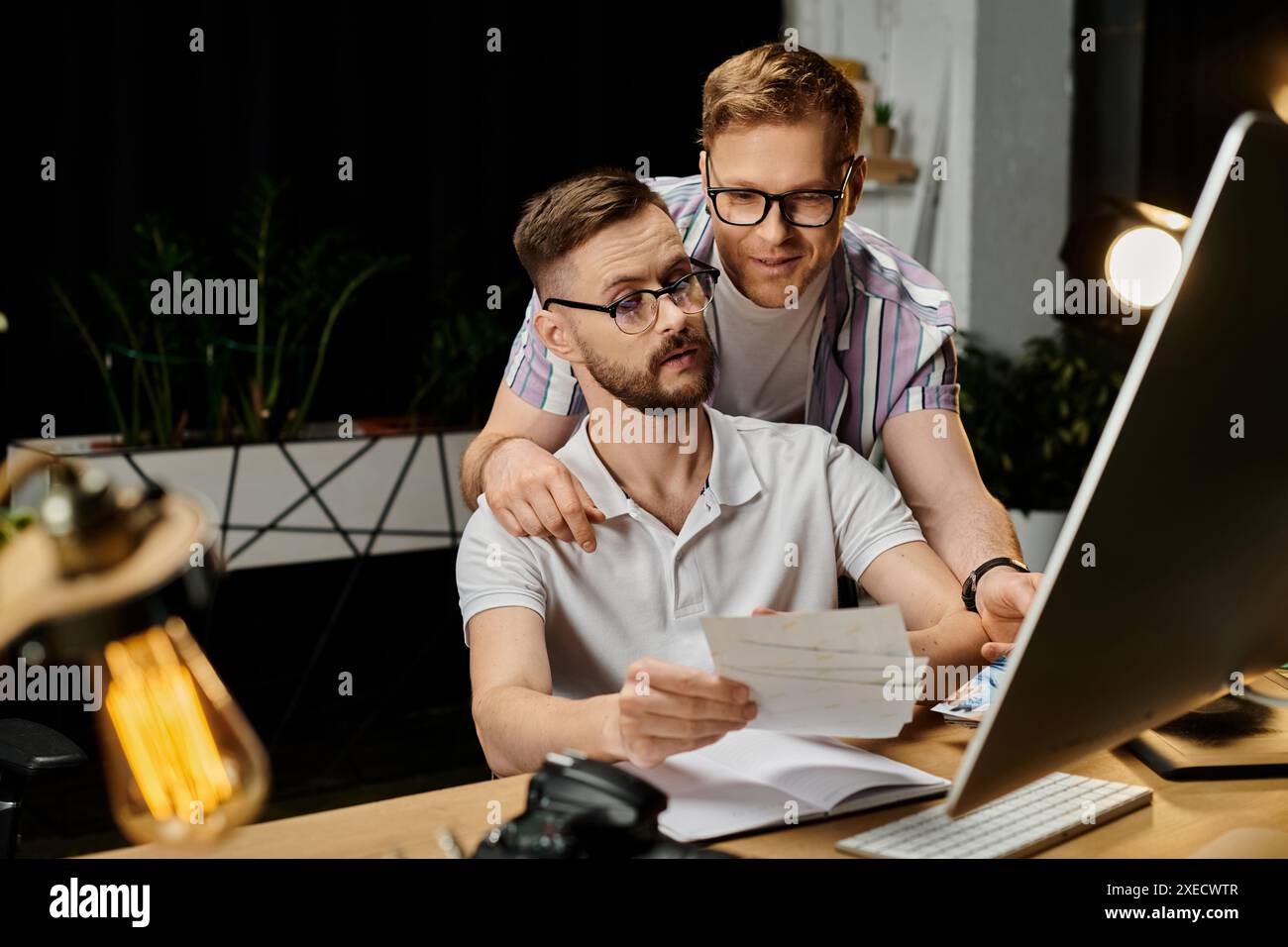 Two loving men focus on computer screen in office Stock Photo - Alamy