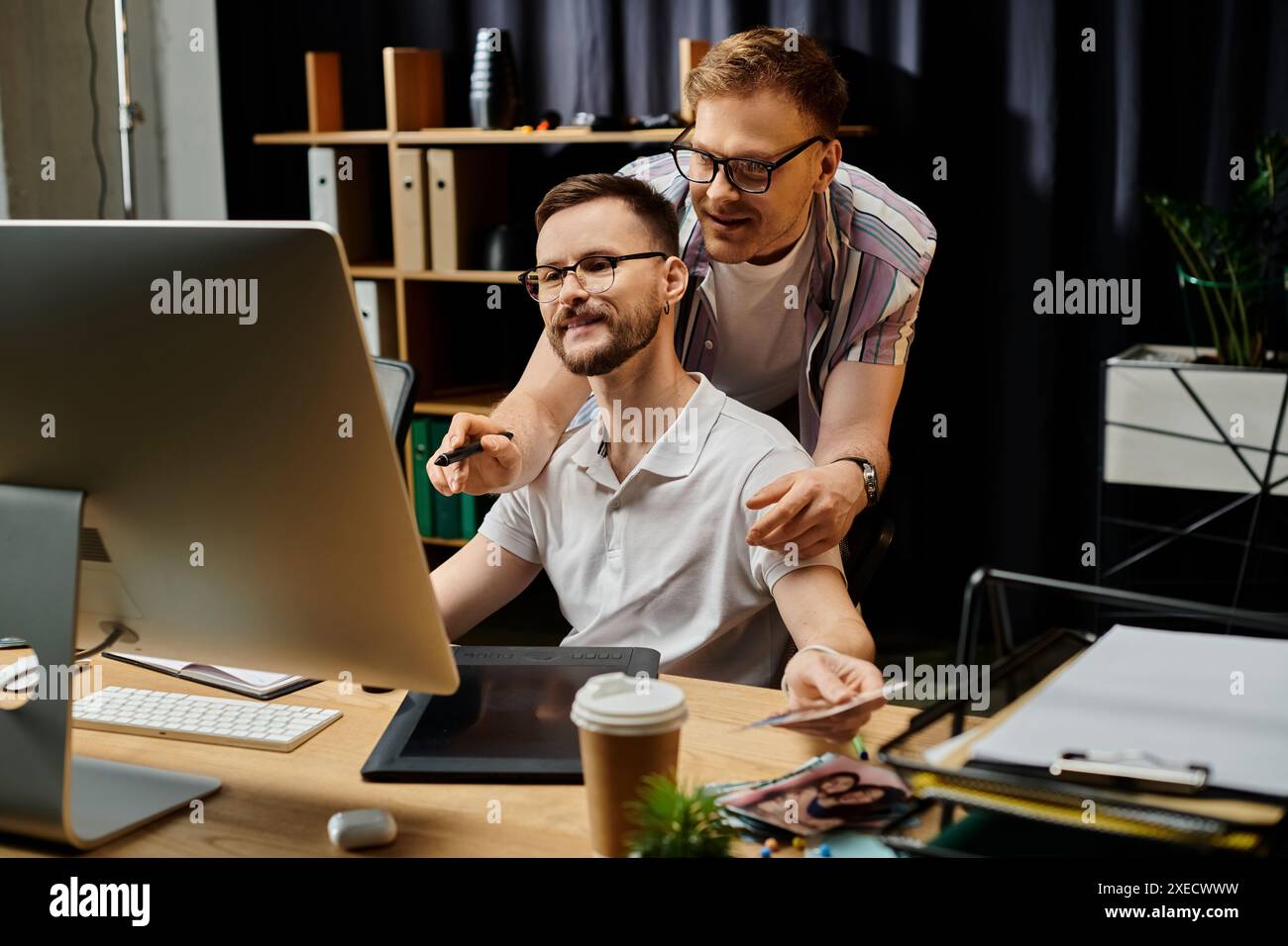 Two men in office attire engaging with a computer screen Stock Photo ...