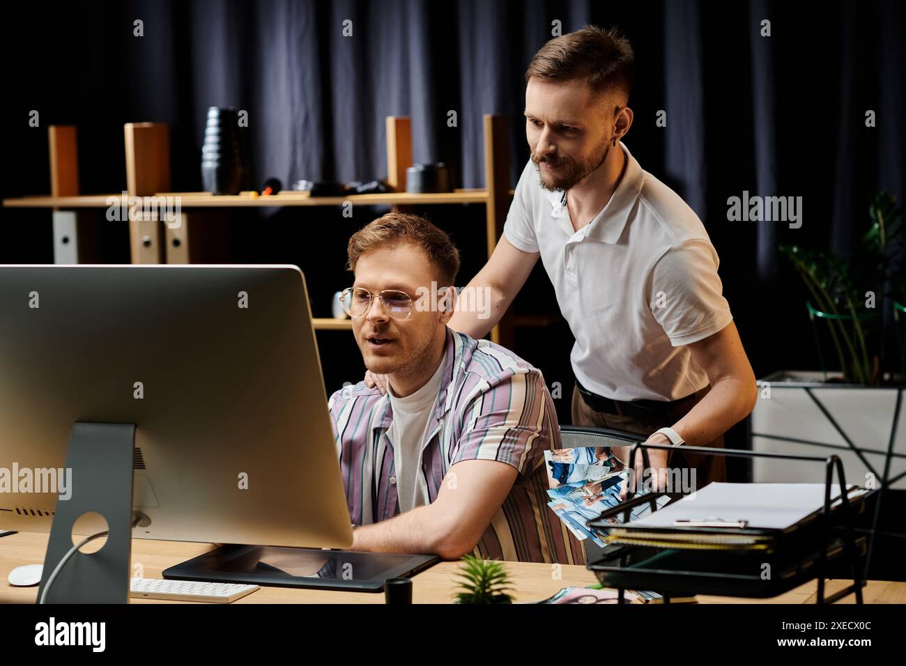 Two men engaged, captivated by data on a screen Stock Photo - Alamy