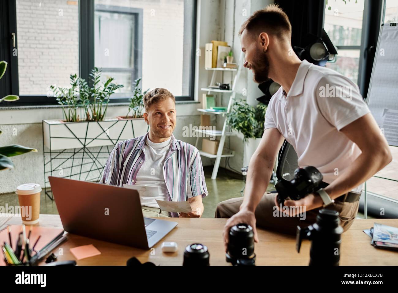 Two loving men in front of a laptop computer, engaging in work Stock ...