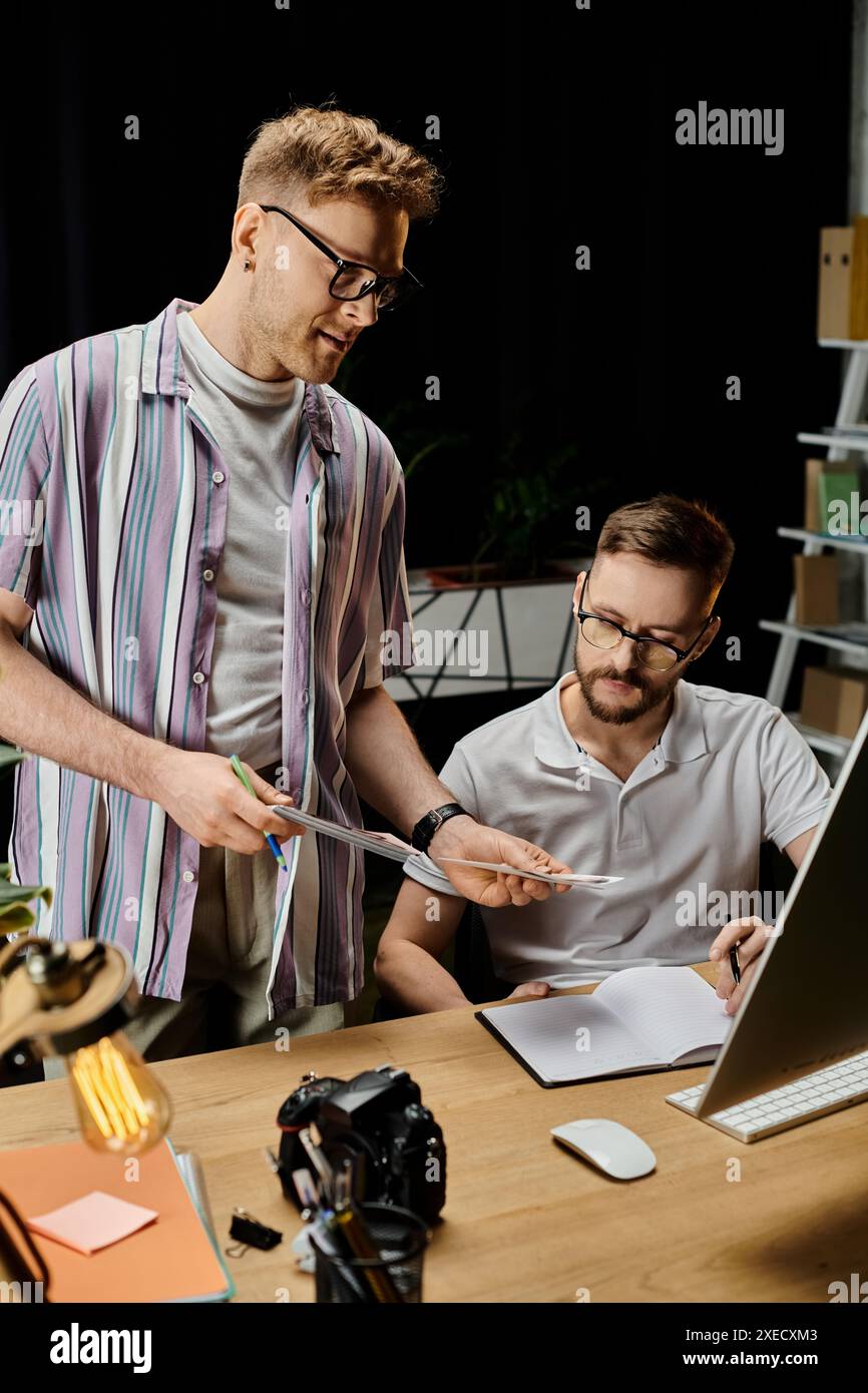 Two men standing, collaborating in front of a laptop computer Stock ...