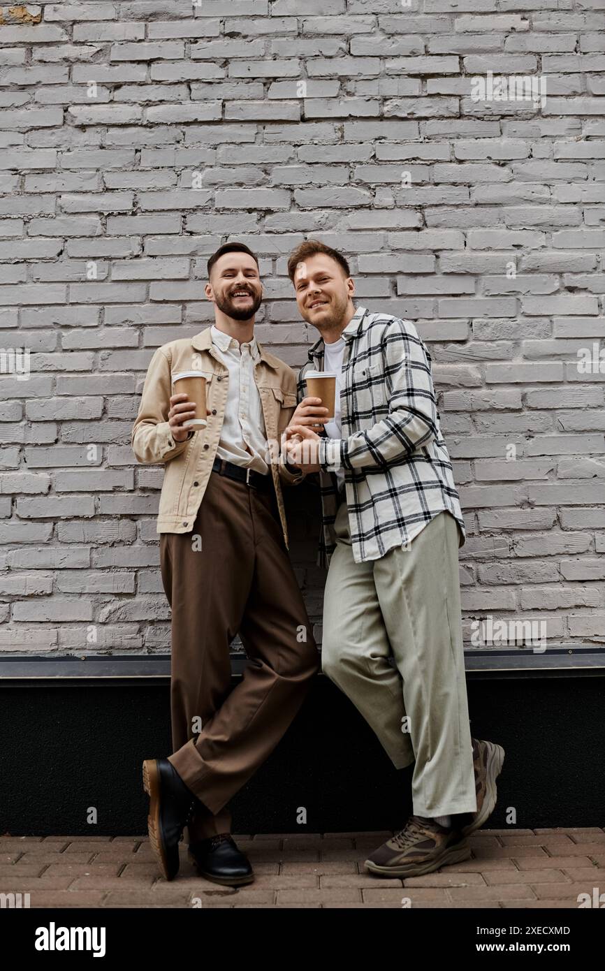 Two men stand side by side in front of a brick wall, exuding a sense of ...