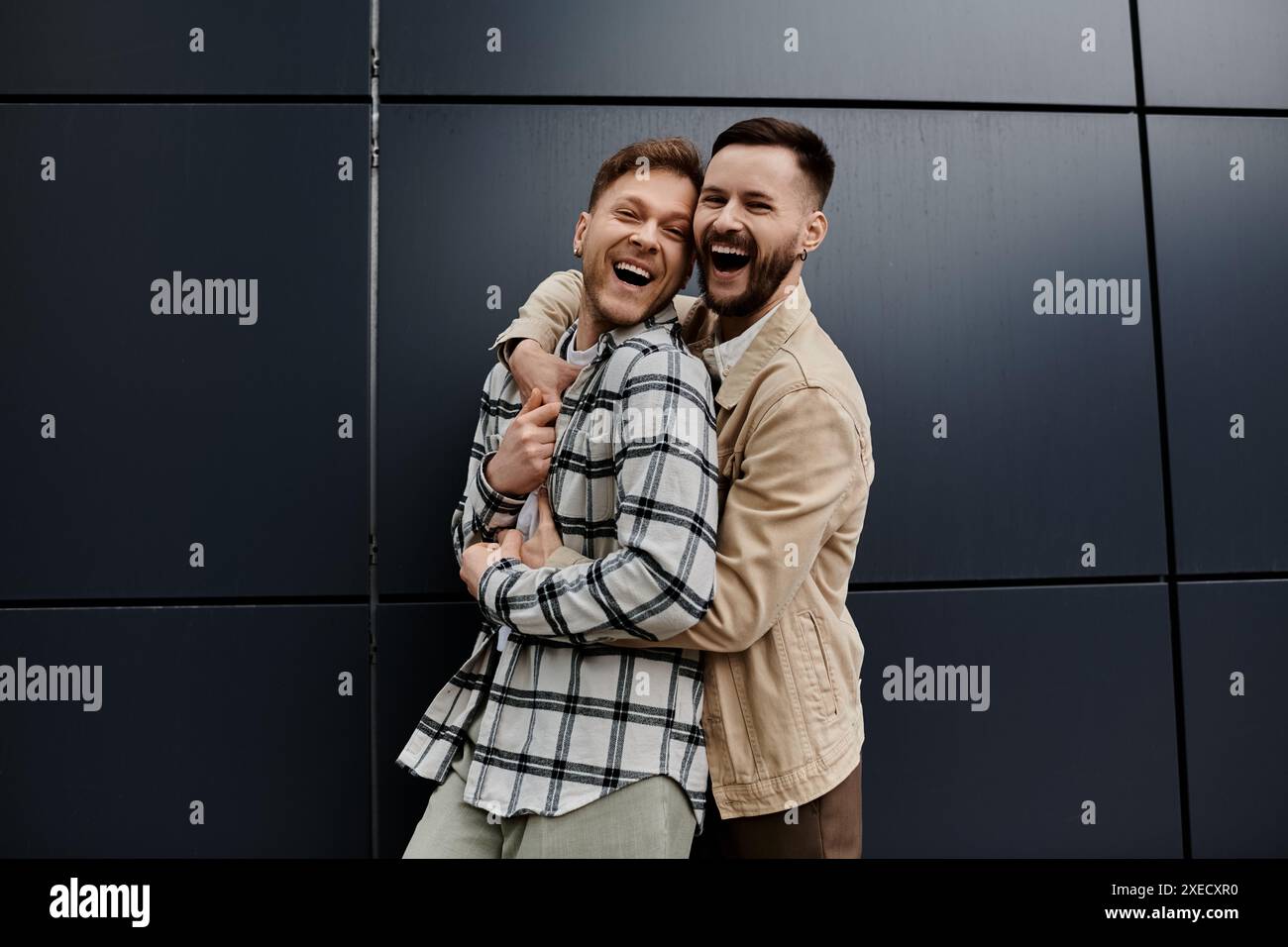 Two men standing together, arms wrapped around each other happily Stock ...