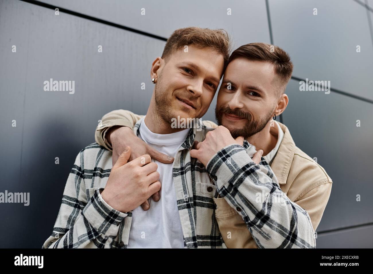 Two men in casual attire standing happily in front of a building Stock ...