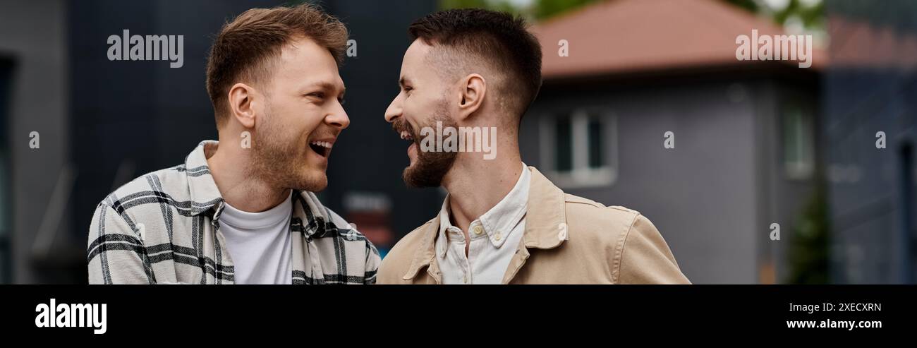 Two men in casual attire, happily standing side by side outdoors Stock ...