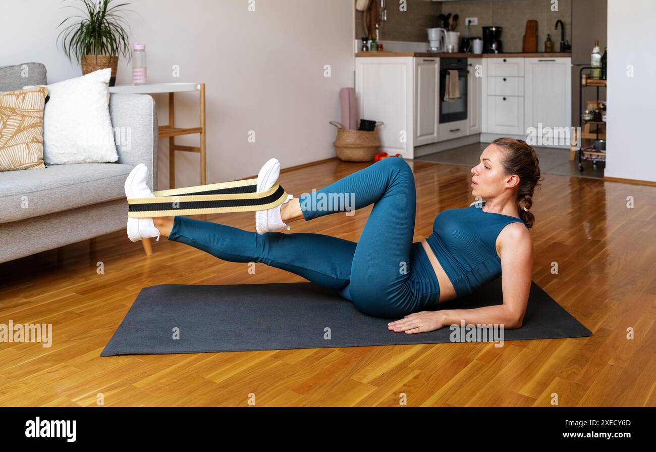 Athlete woman doing workout exercise using mini resistance band on yoga ...