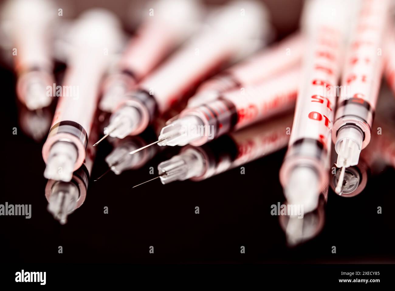 This photograph captures an array of medical insulin syringes closely ...