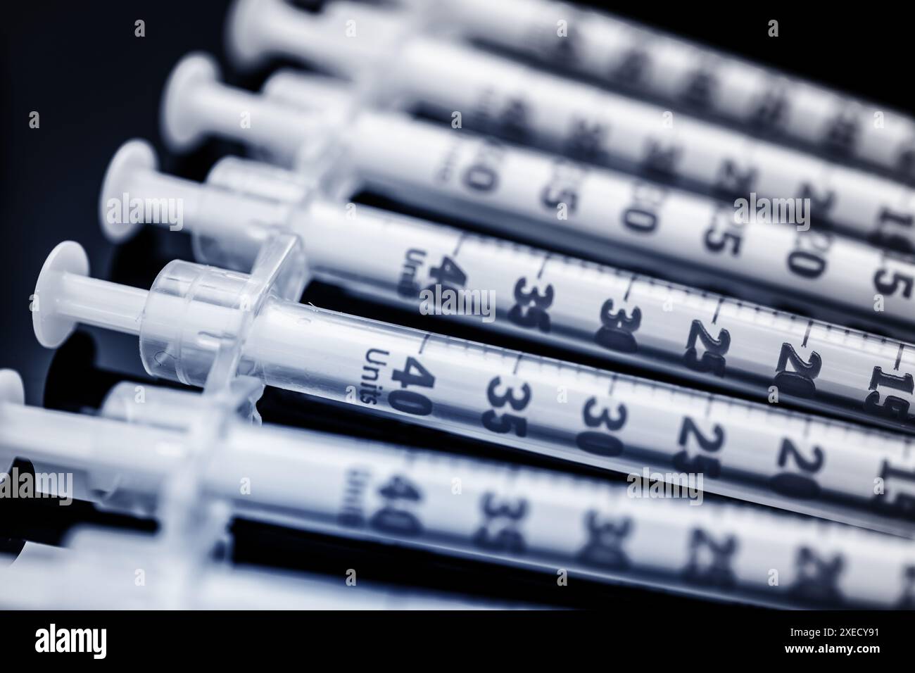 A close-up view of several aligned medical syringes with focus on the ...