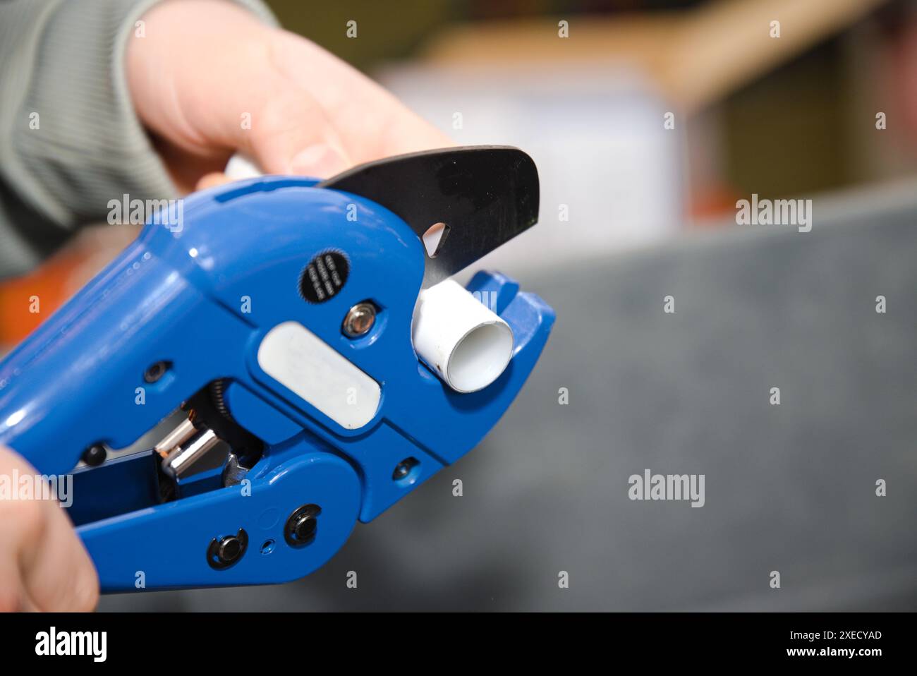 Craftsman plumber with pipe cutter - close up tool of skilled worker ...