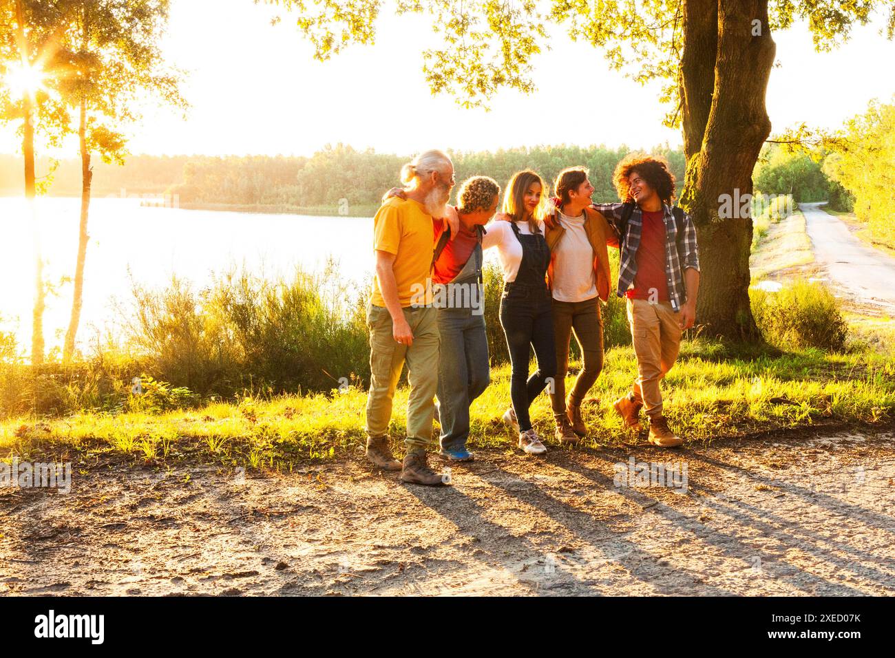 Group of Friends Enjoying Sunset Walk by the Lake Stock Photo - Alamy