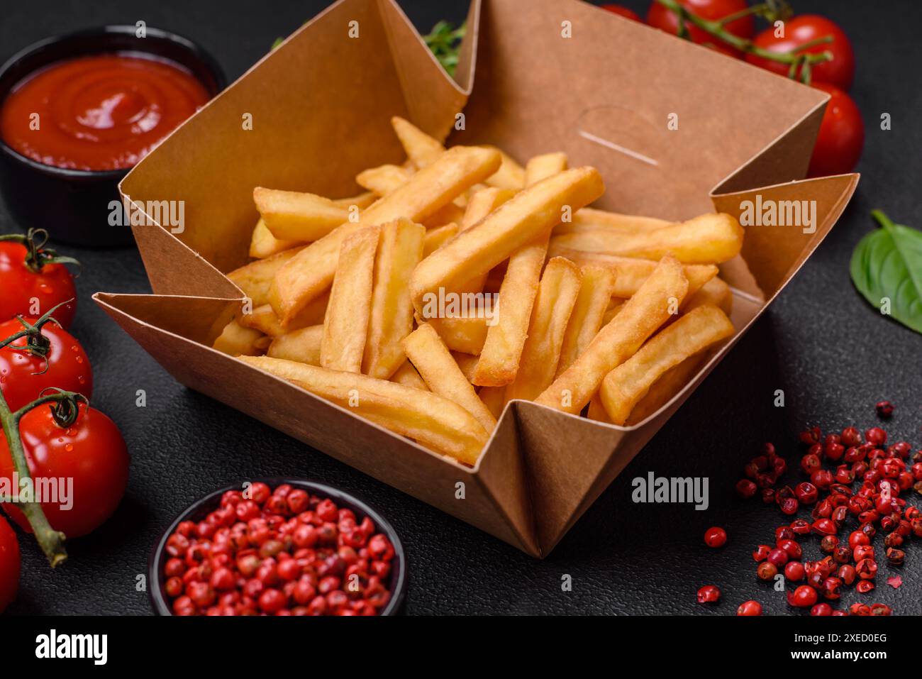 Delicious crispy french fries with salt and spices in a cardboard box ...