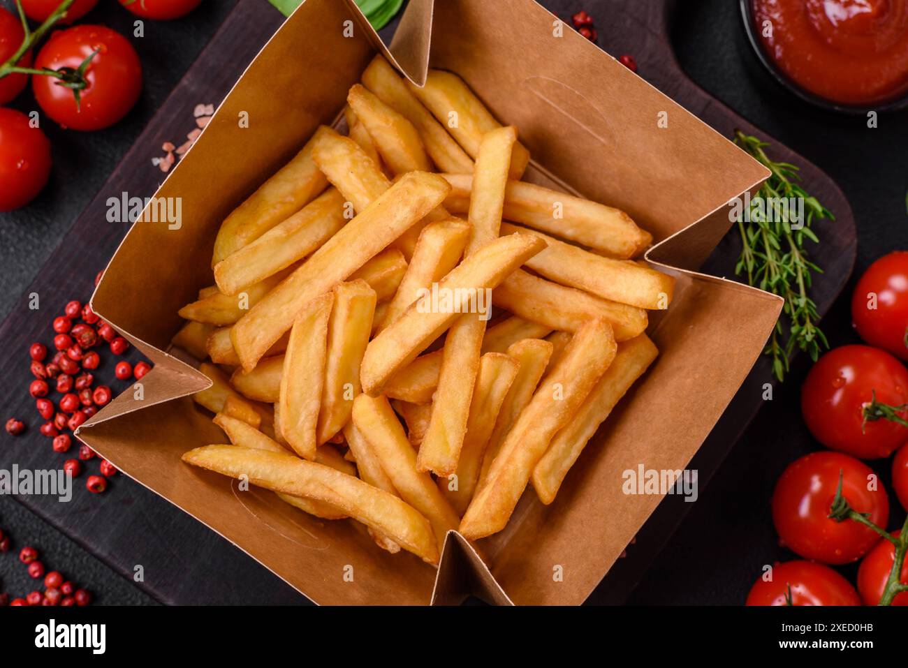 Delicious crispy french fries with salt and spices in a cardboard box ...
