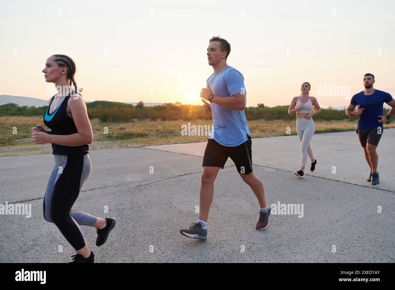 A diverse group of runners trains together at sunset Stock Photo - Alamy