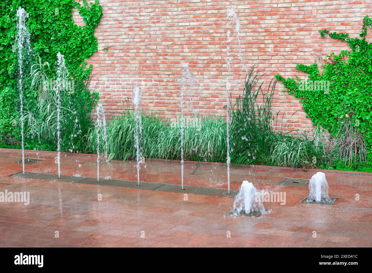 Wall with a brick facade and a row of fountains. The fountains are ...