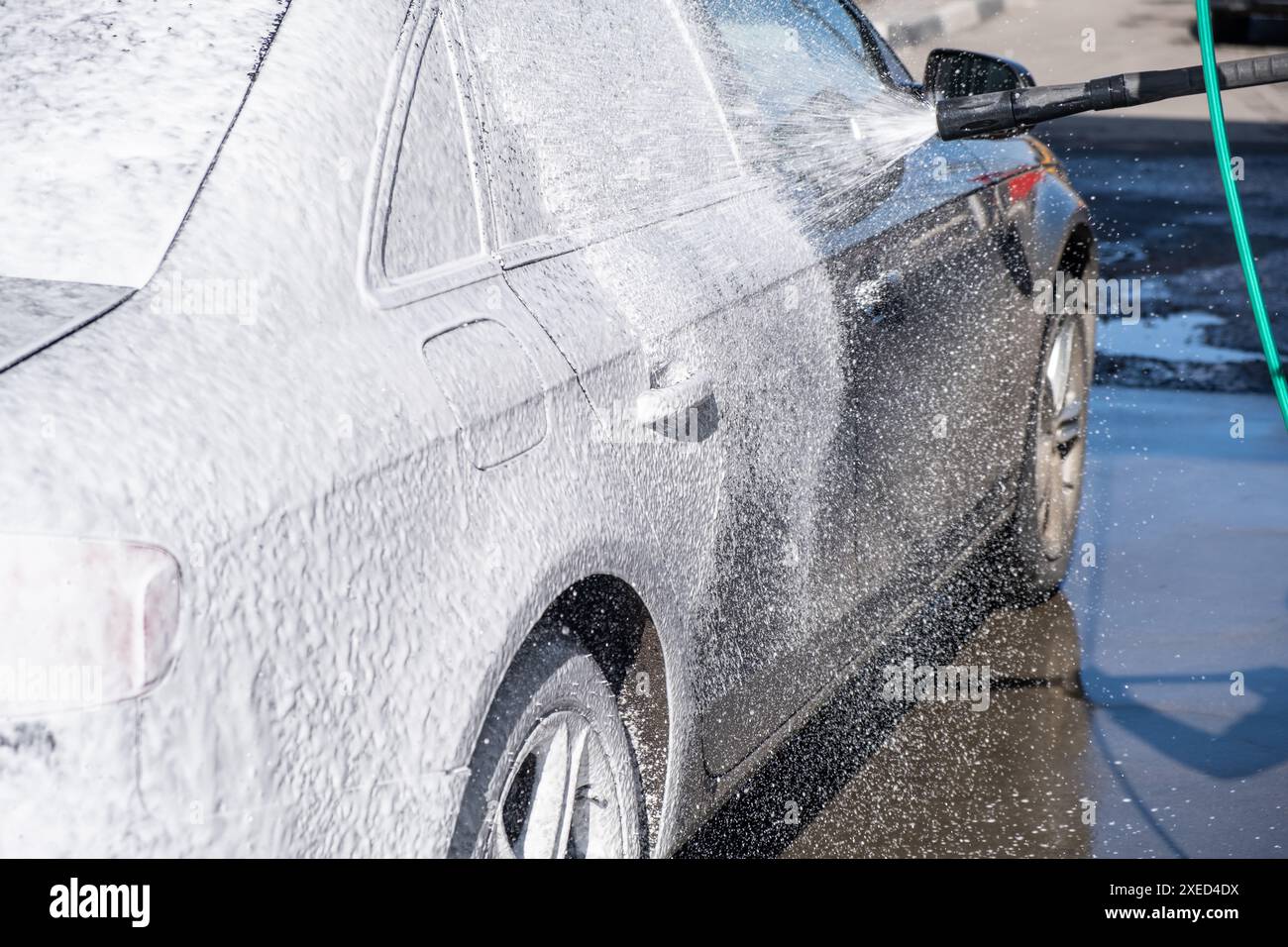 Foamy car at car wash, with tire, wheel, and hood covered in suds Stock ...