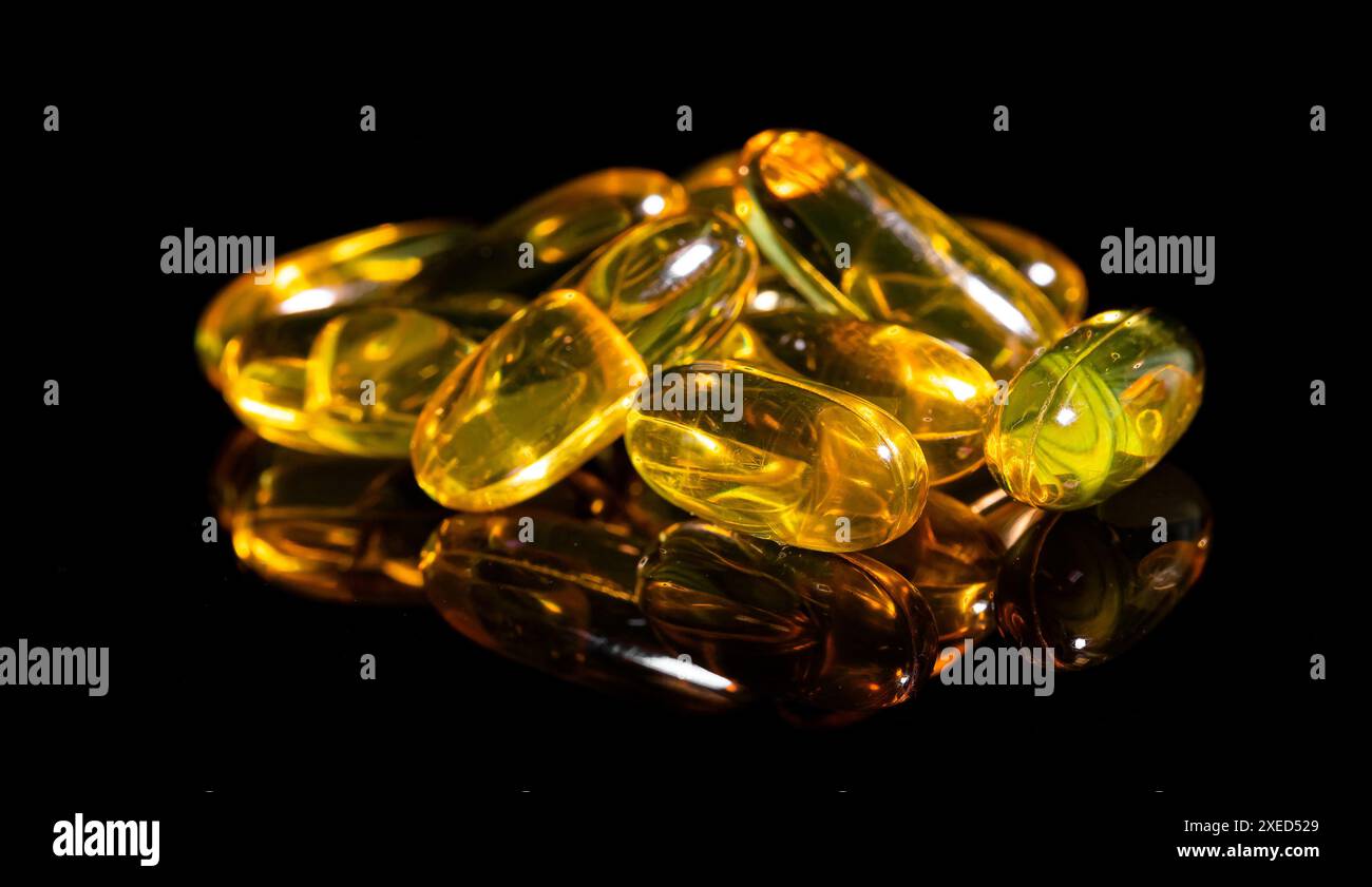 Close up of Omega 3 gel capsule on a reflective black background Stock ...
