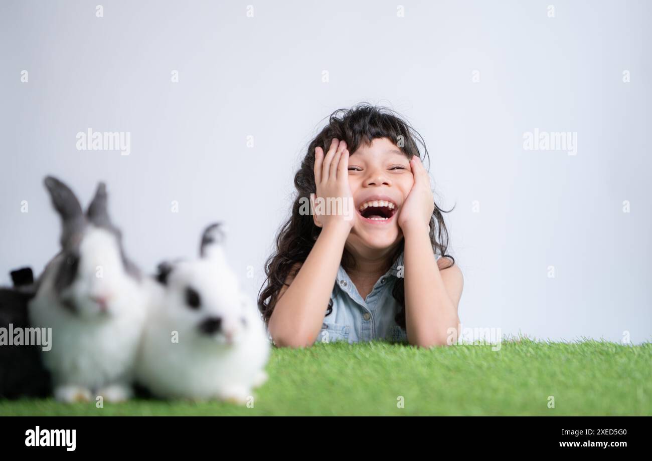 Smiling little girl and with their beloved fluffy rabbit, showcasing ...