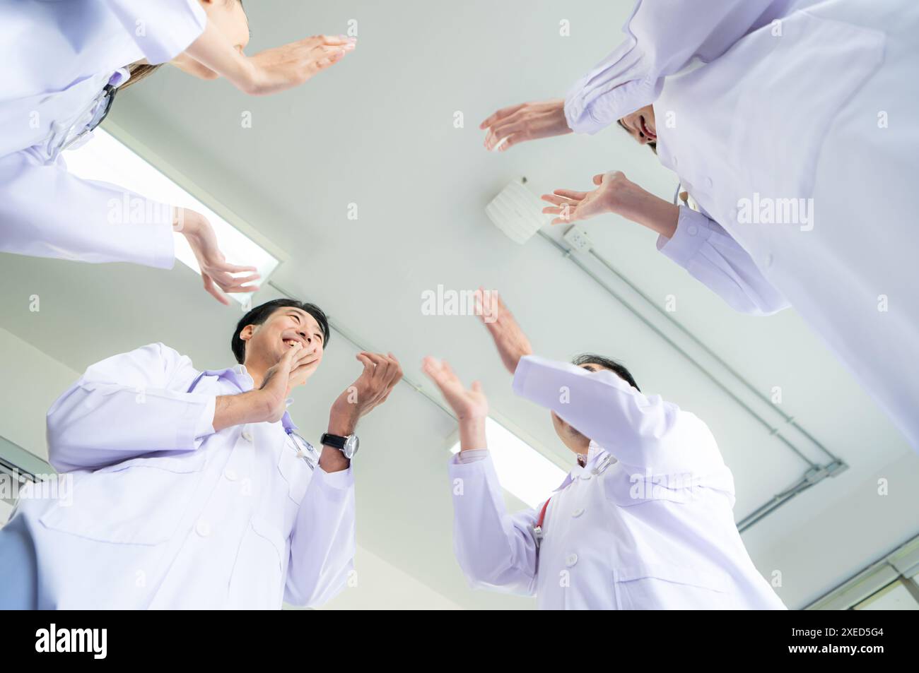 A delighted doctor team enjoying achievement in a hospital setting with ...
