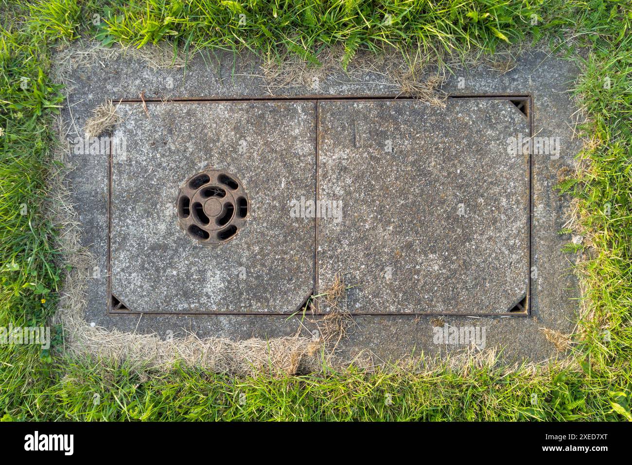 Old Concrete Utility Cover with Grass Stock Photo - Alamy