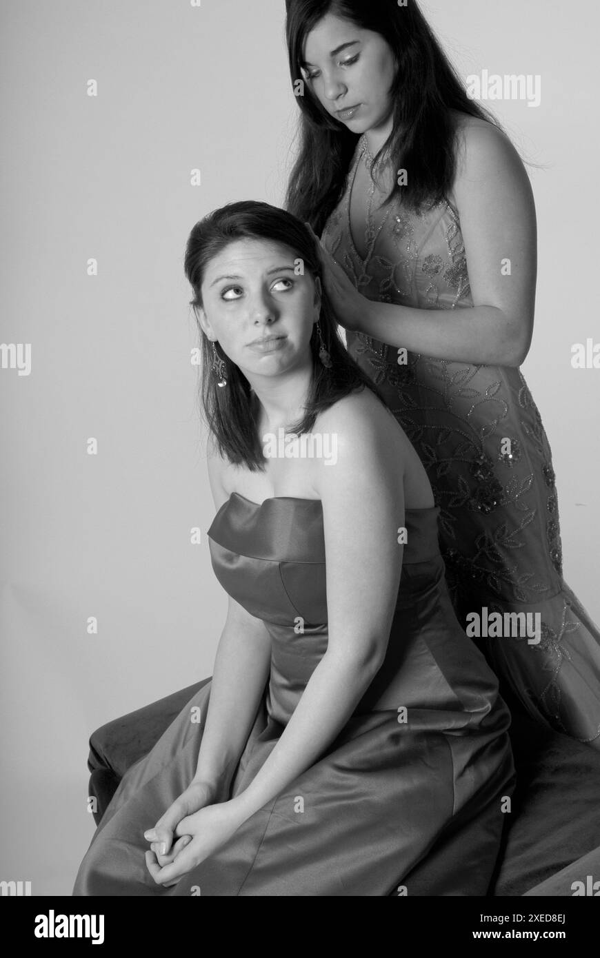 Two teenage girls help each other get ready for prom night in the USA ...