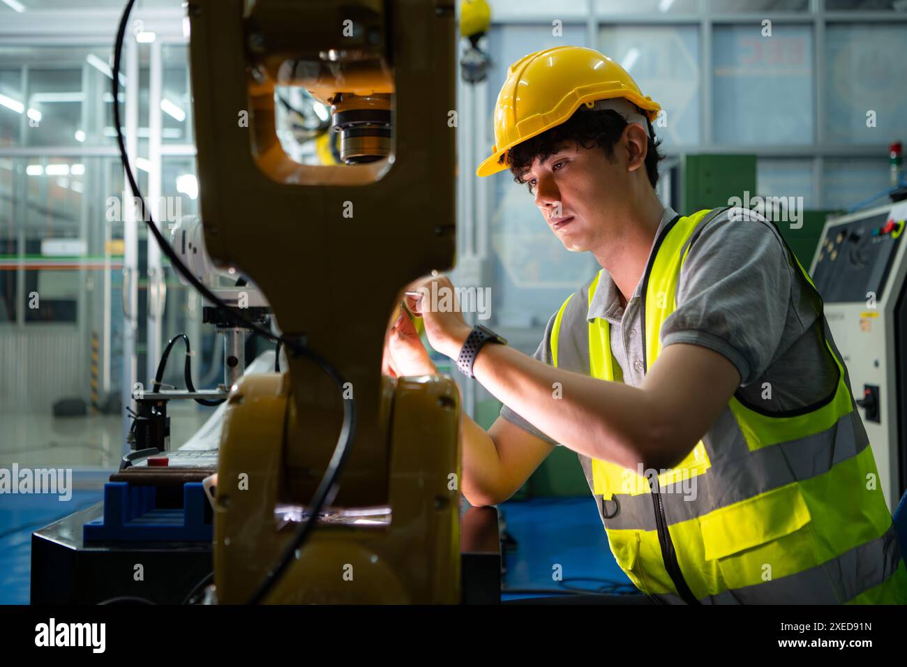 Technician who maintains a small robot arm the operation of a small ...