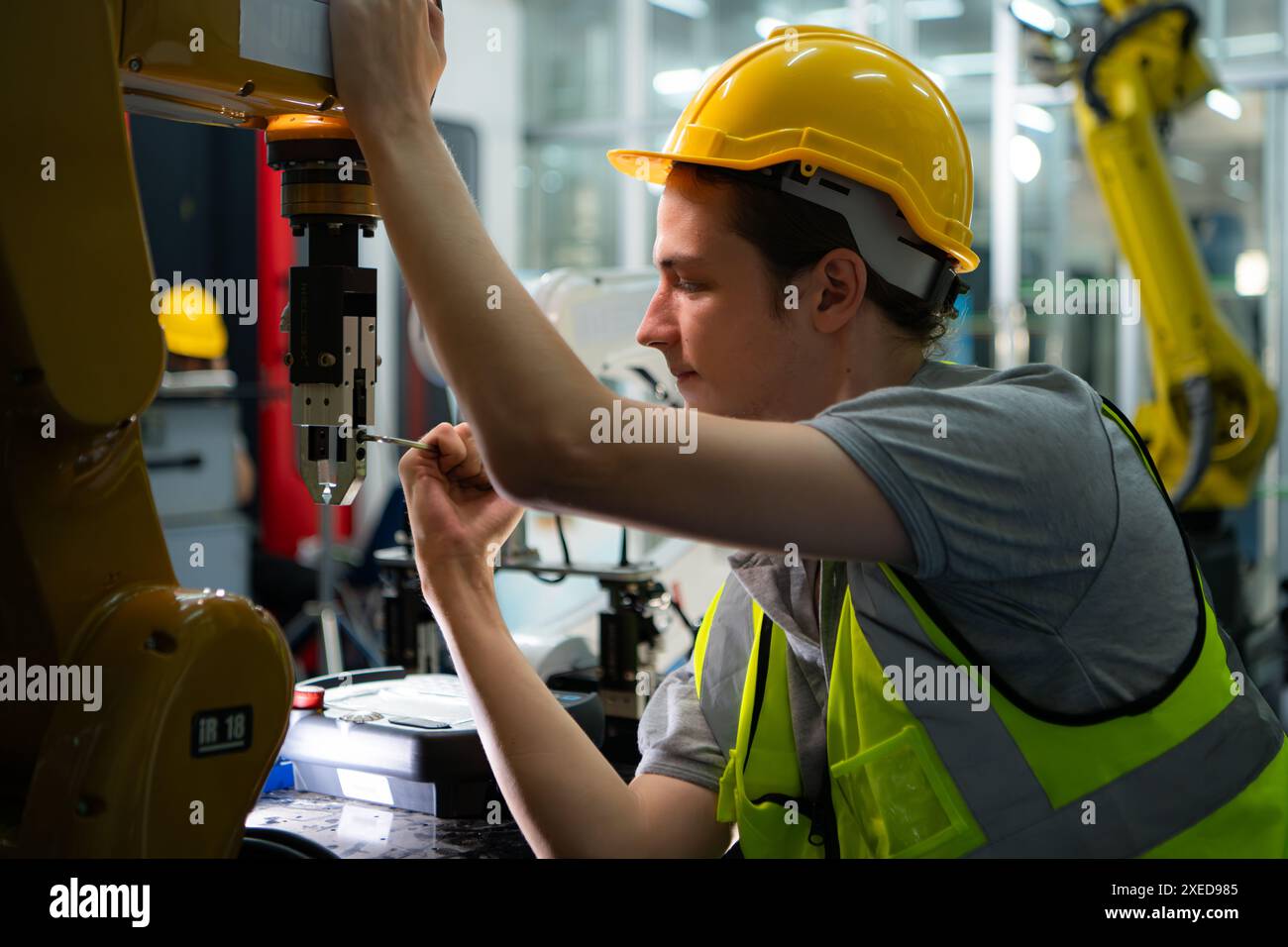 Technician who maintains a small robot arm the operation of a small ...